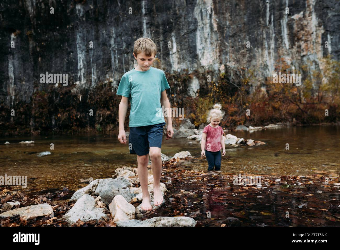 Kids wading in water in scenic river during autumn Stock Photo - Alamy