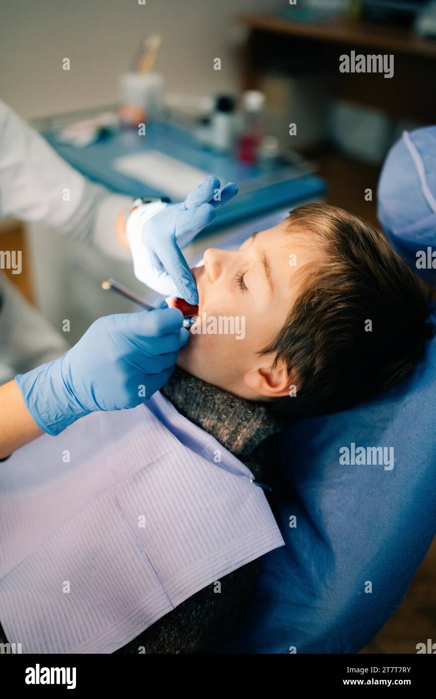 Woman dentist treating teeth to boy patient Stock Photo - Alamy