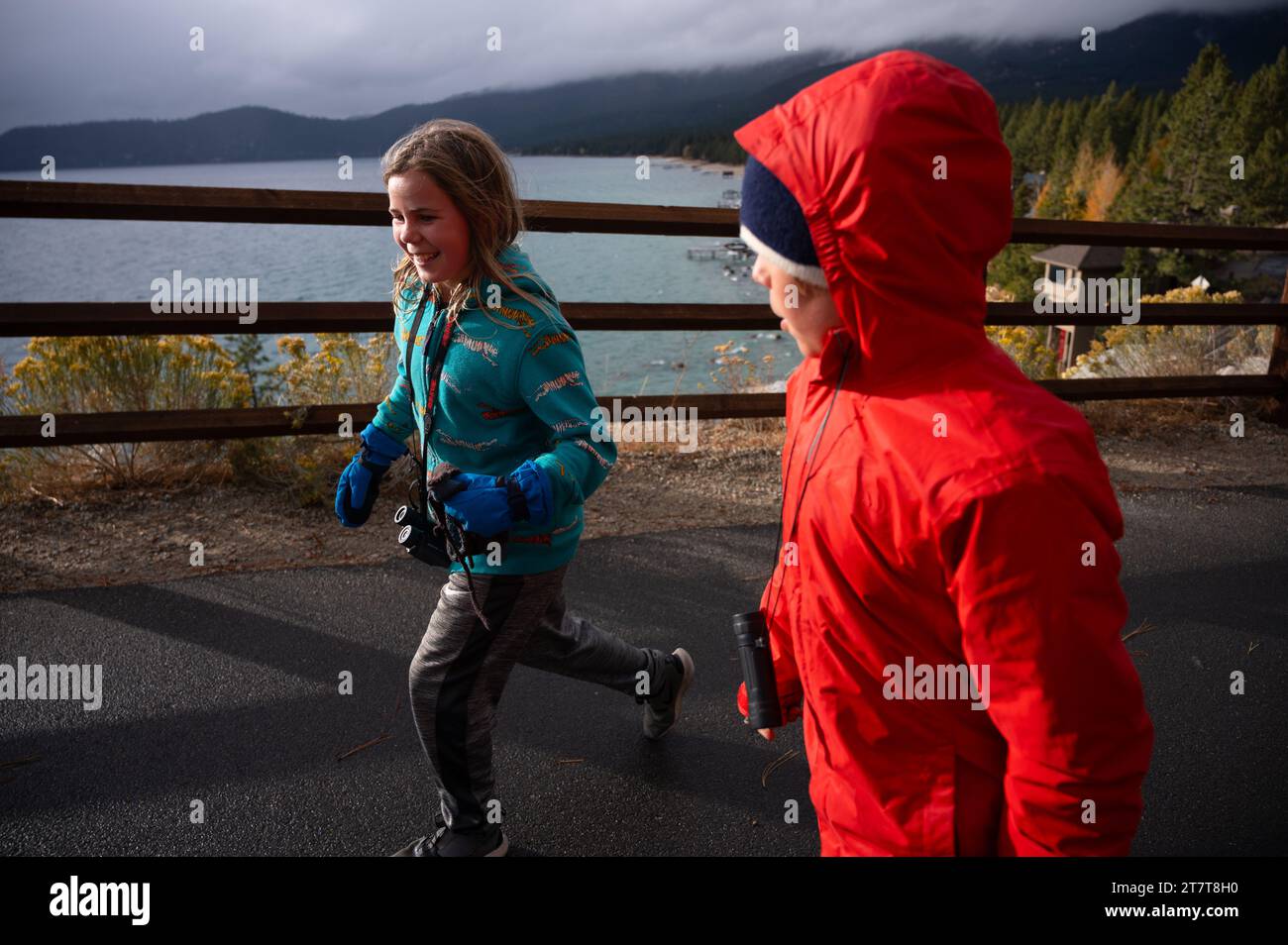 Two tween siblings walking along trail at Lake Tahoe in the autumn ...
