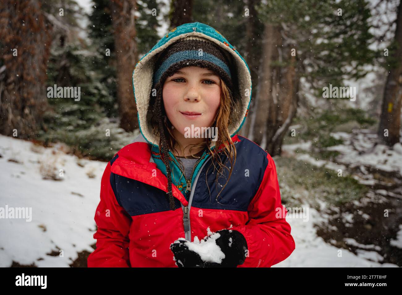 Smiling boy in red coat eating snow in winter Stock Photo - Alamy