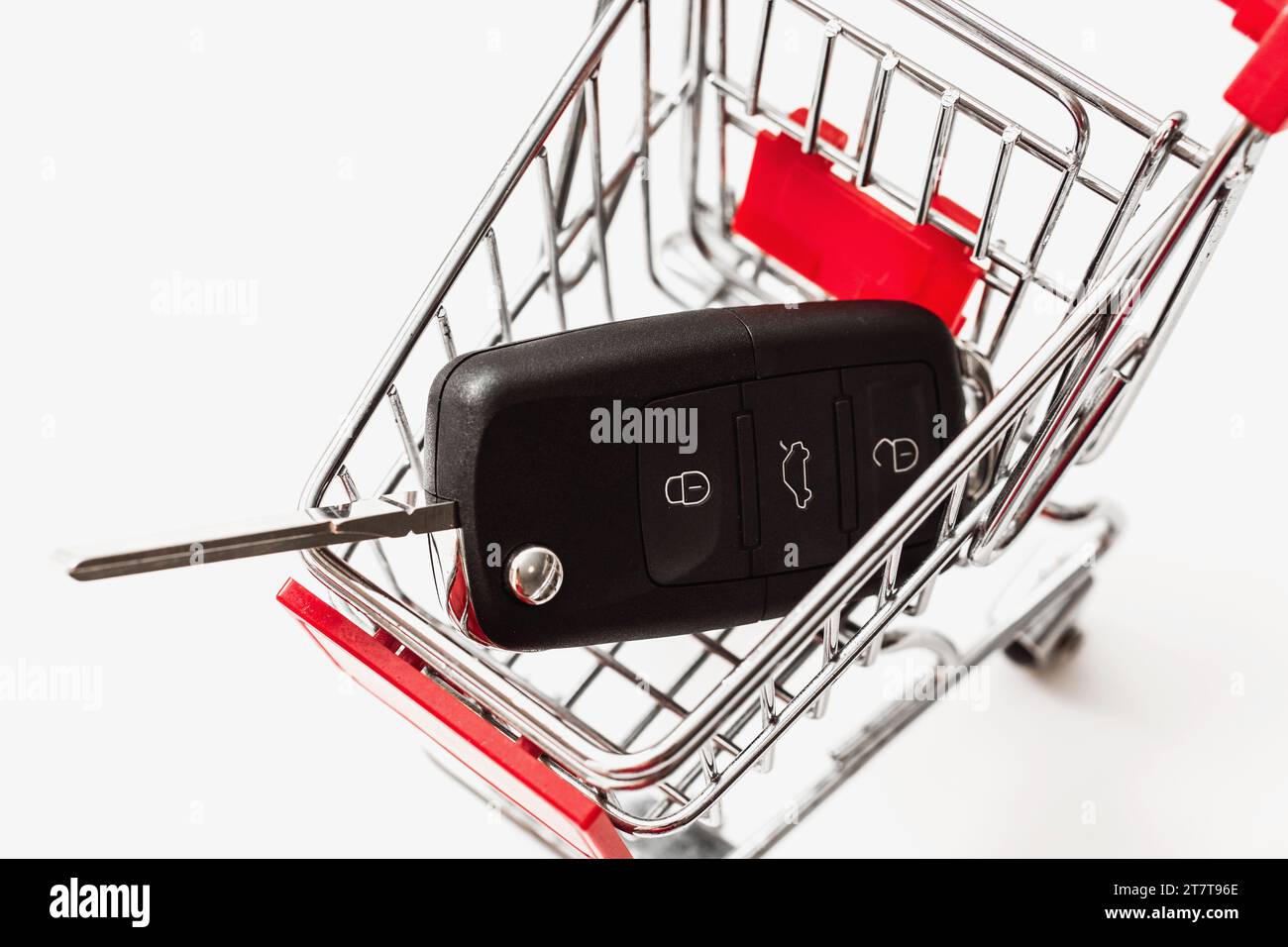 Black car key inside a small shopping cart on white background Stock ...
