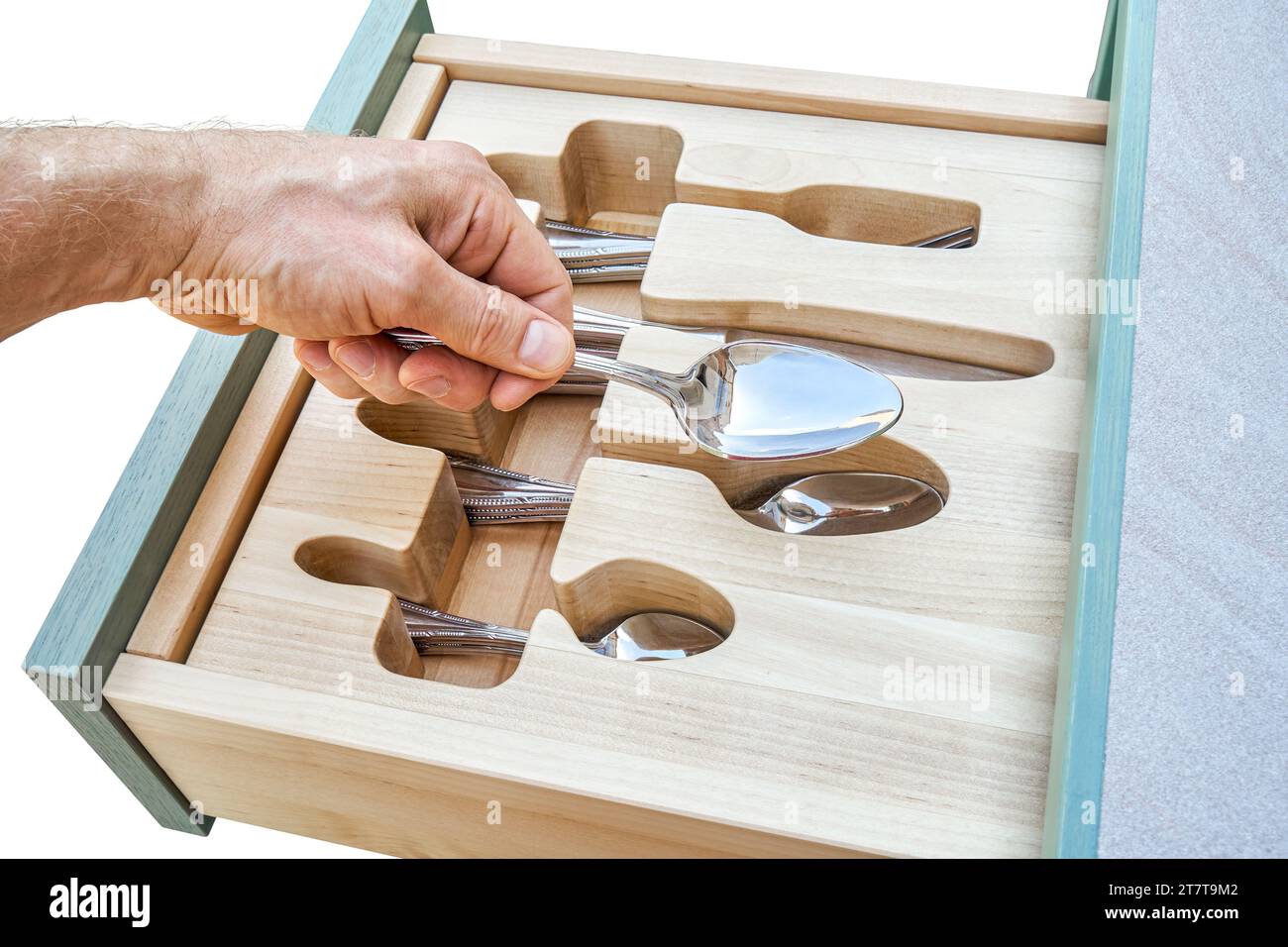 Man hand puts spoon in craved wooden holder in kitchen cabinet drawer ...