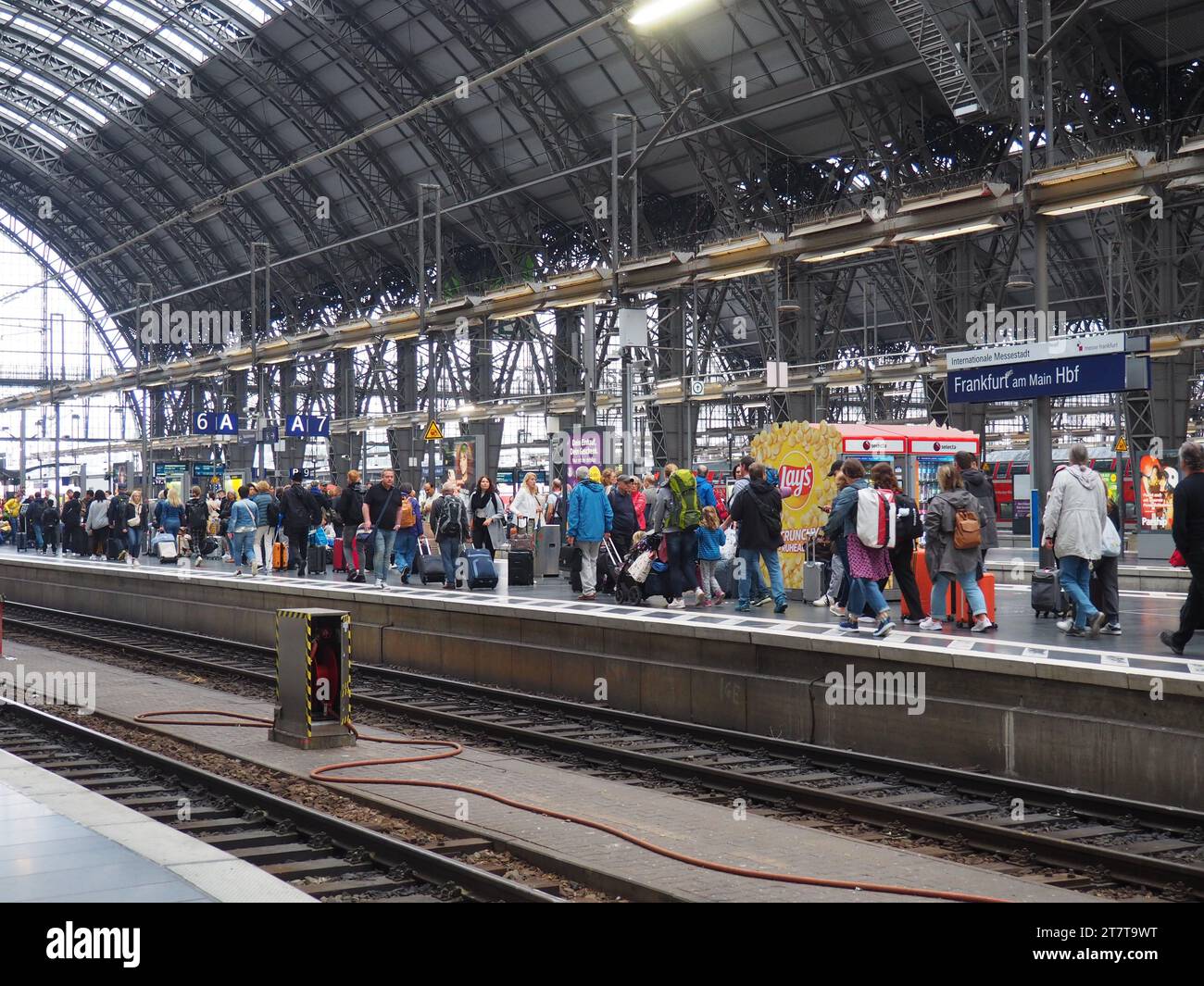 A crowded platform with people and trolleys inside Frankfurt station ...