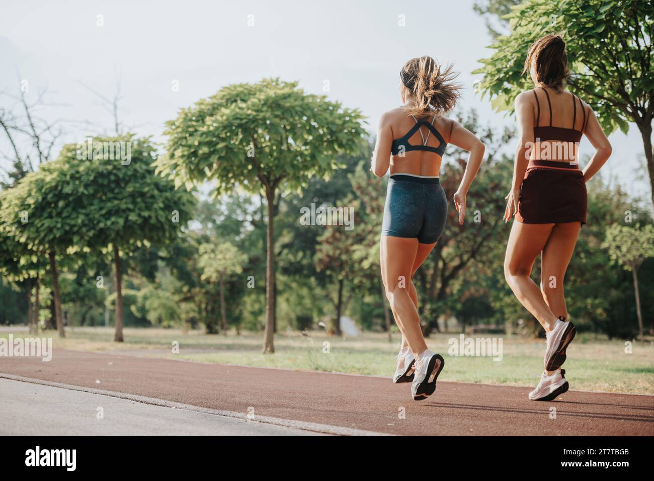 Two fit women jogging in nature. They inspire with their healthy ...