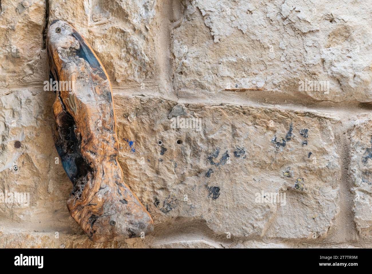 A mezuza scroll is mounted to a stone wall at the entrance to a home in ...