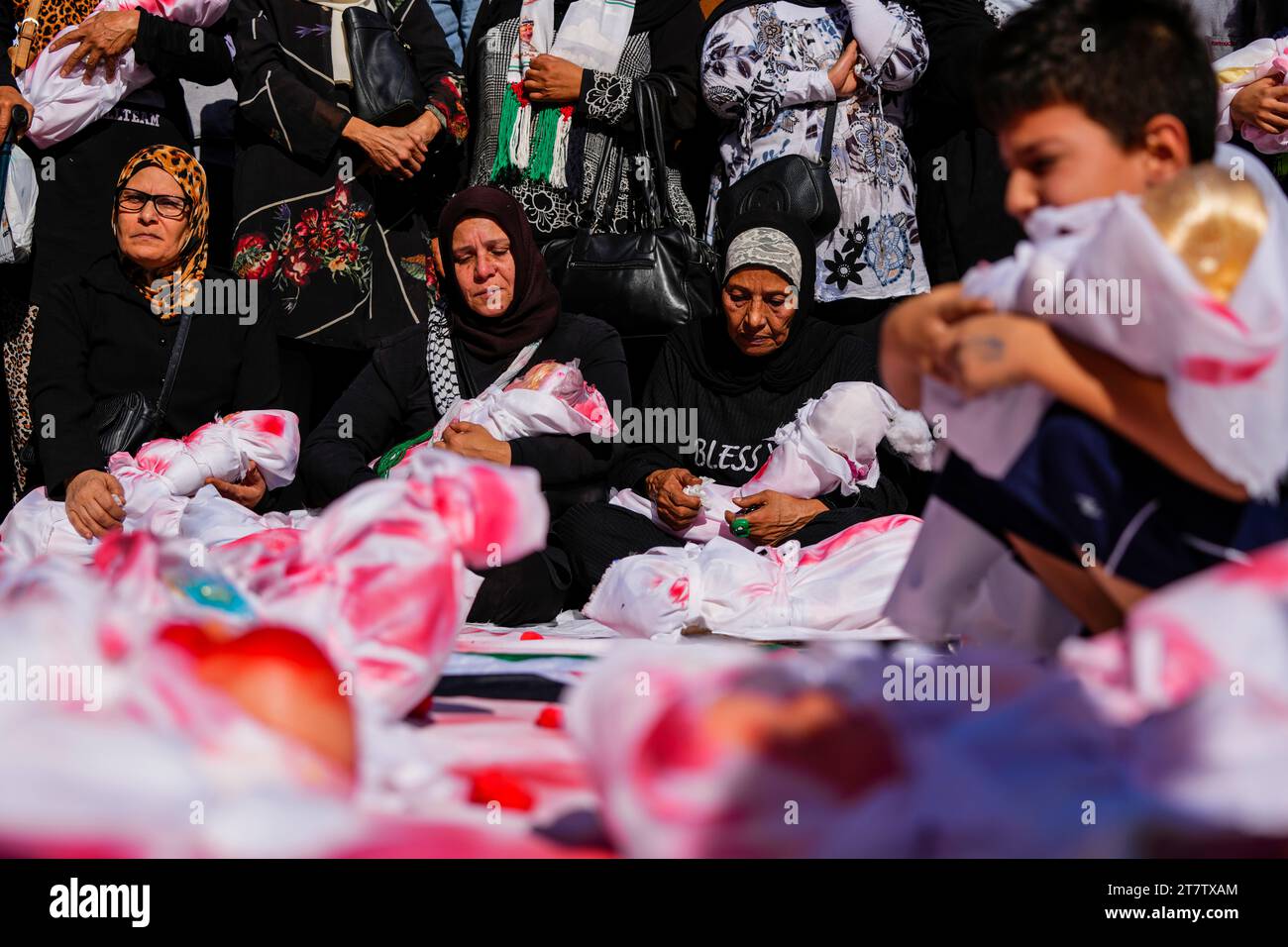 Women cradle mock bodies of dead Palestinian children wrapped in blood ...