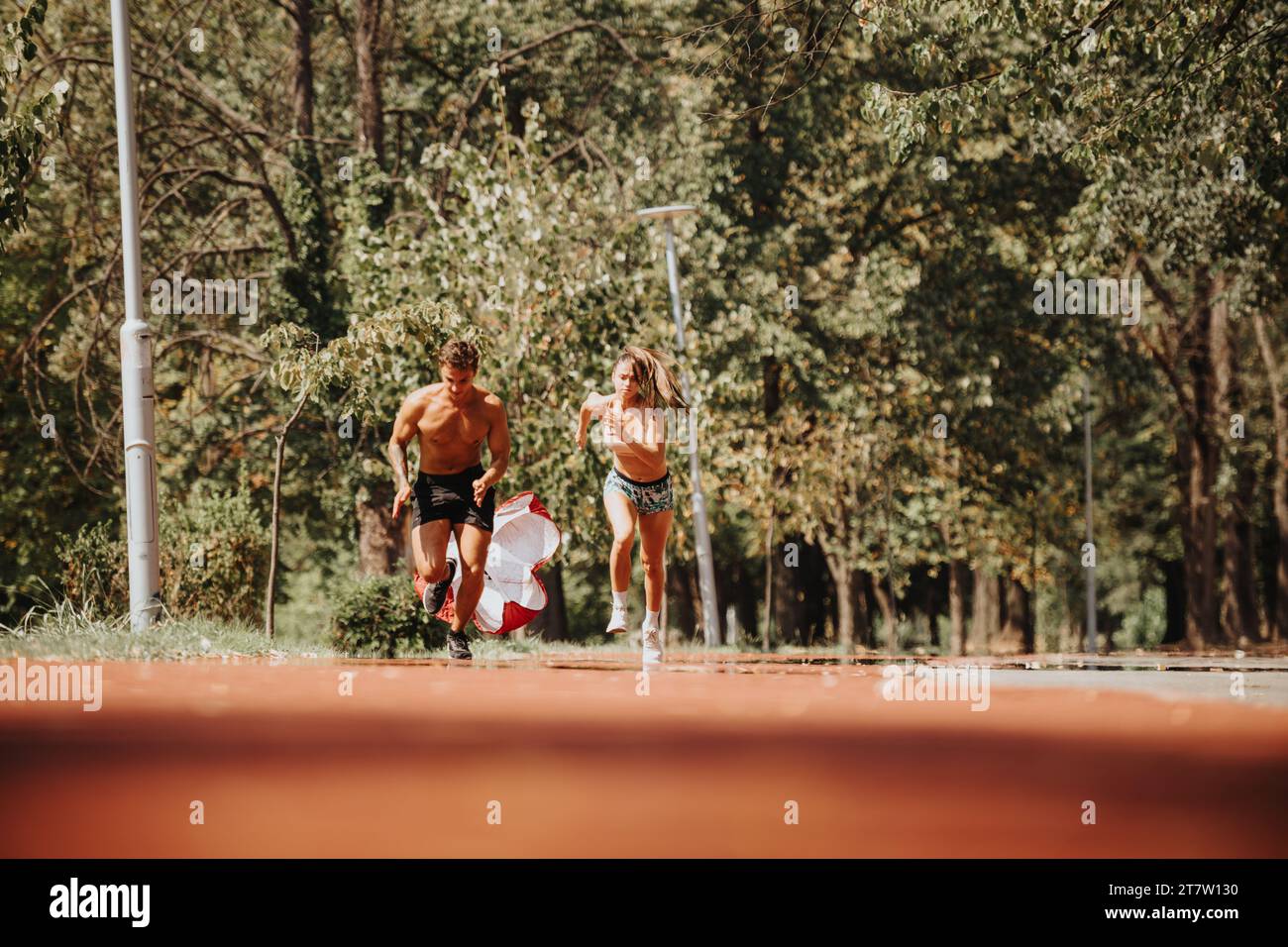 Sunny Outdoor Workout. Athletes Practicing Parachute Running and ...