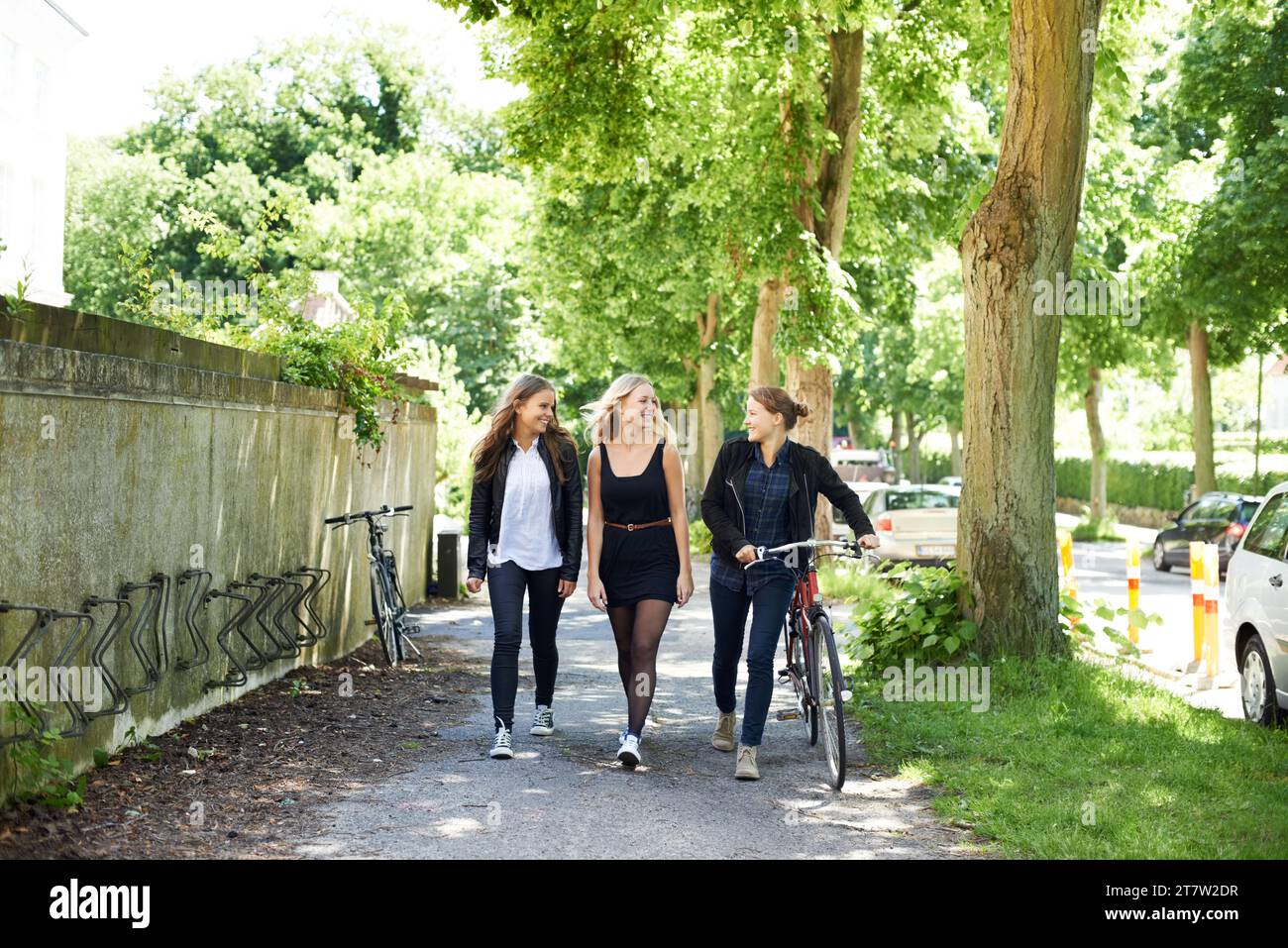 Bicycle, friends and happy women walking at school together for ...
