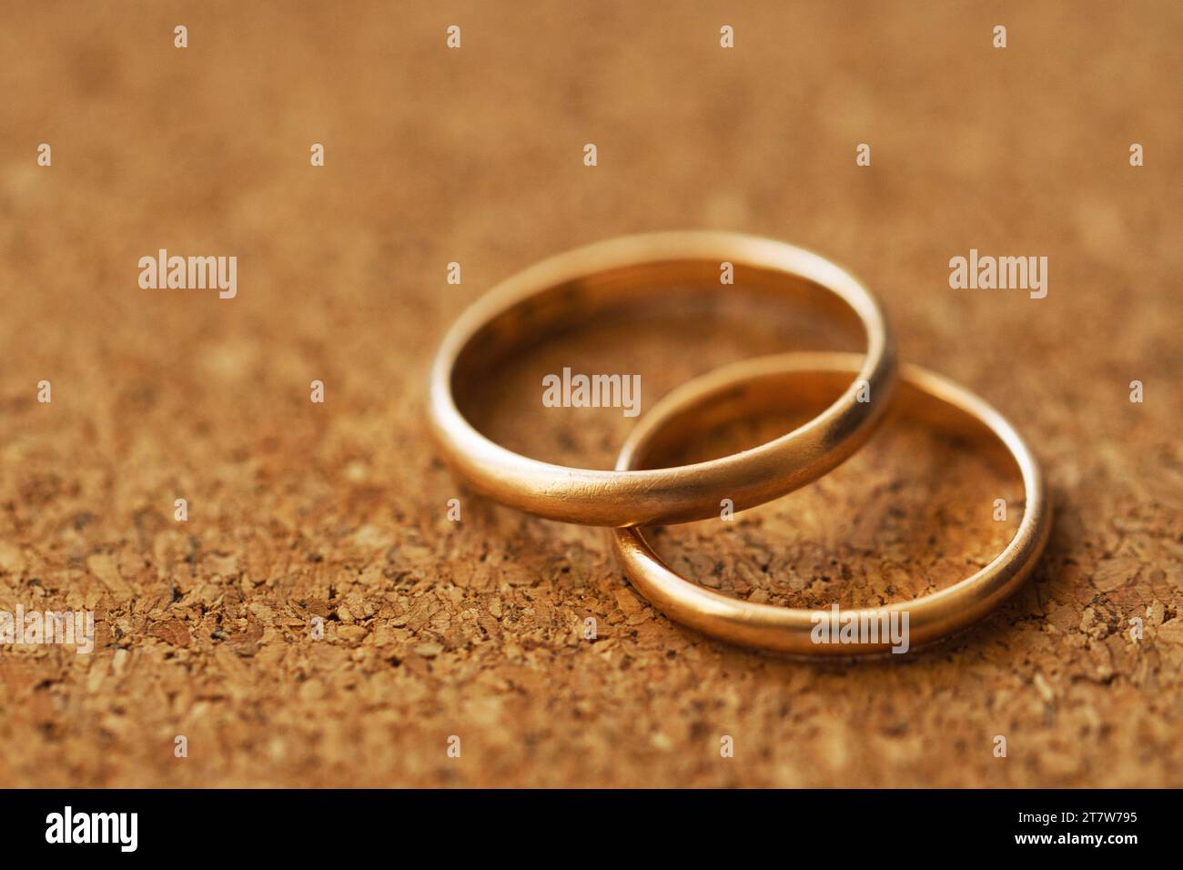 Two wedding rings on a cork table background with shallow DOF Stock ...