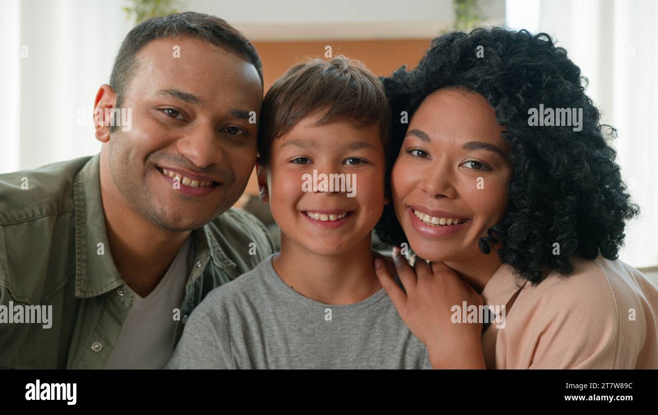 Happy multiracial African American loving mum and dad kissing little ...