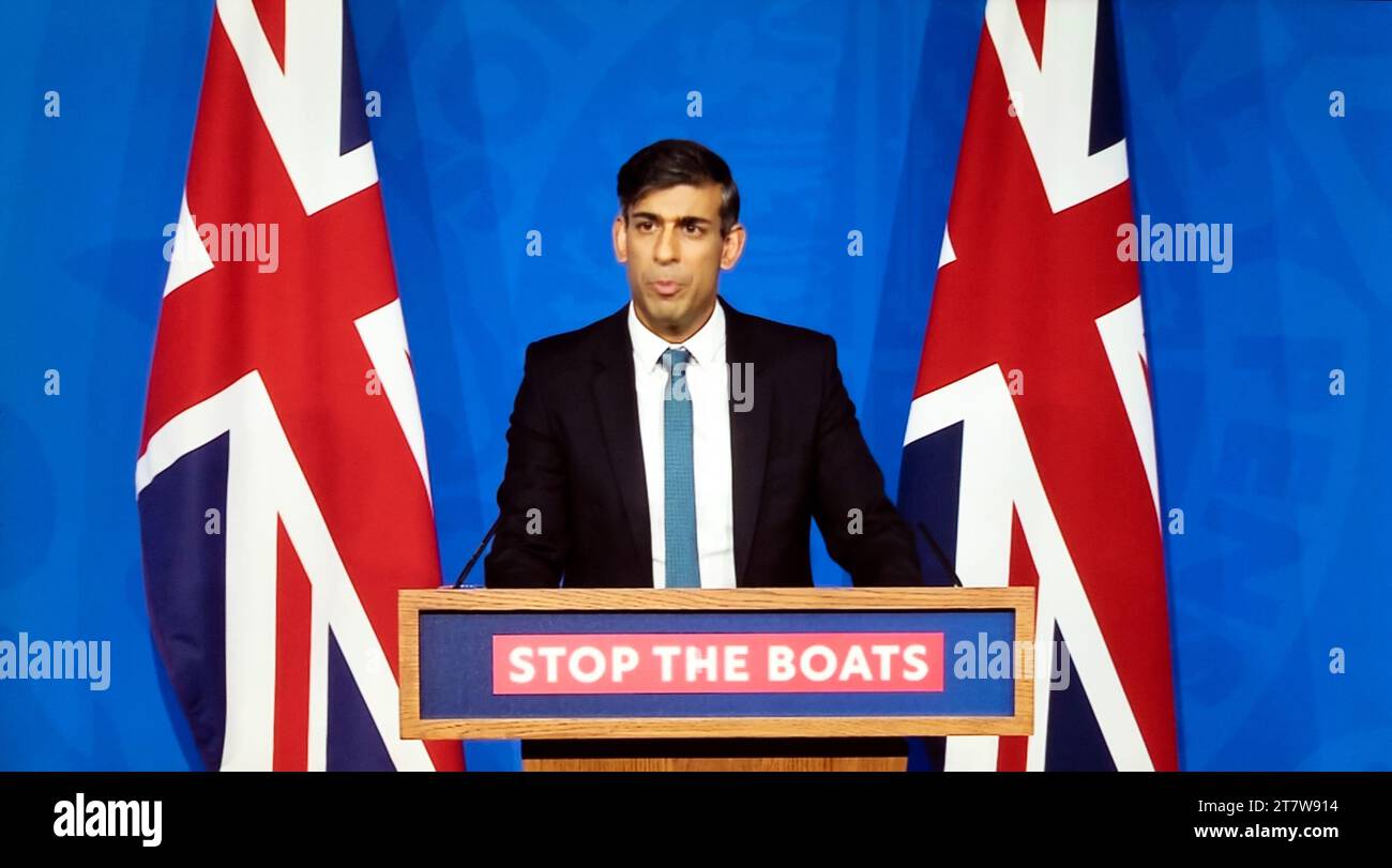 Prime Minister Rishi Sunak standing at podium with Stop the Boats sign ...