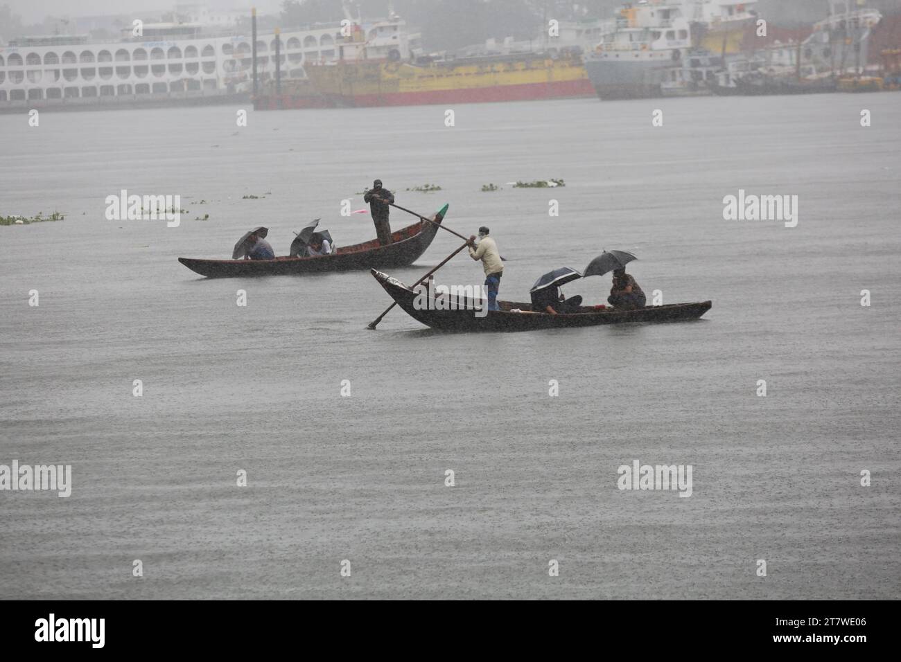 Bangladeshi passengers cross the Buriganga River during the heavy rain ...