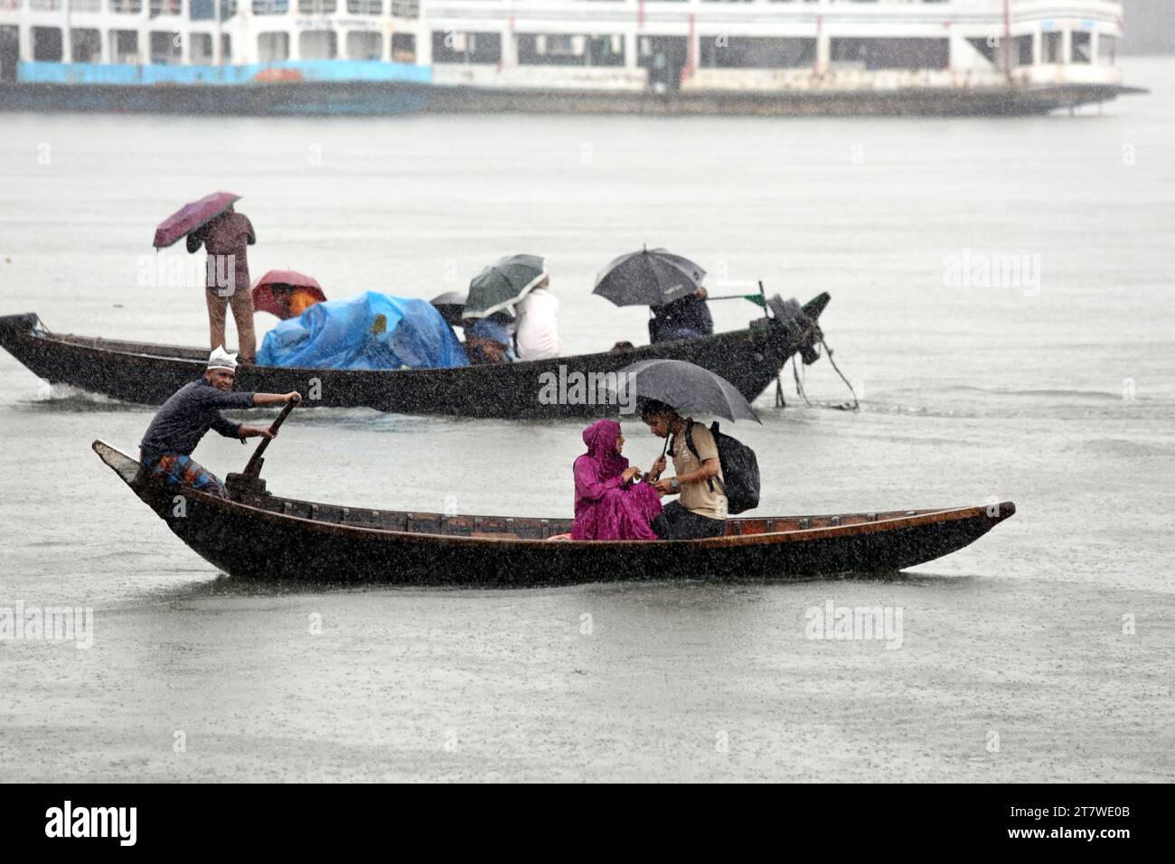 Bangladeshi passengers cross the Buriganga River during the heavy rain ...