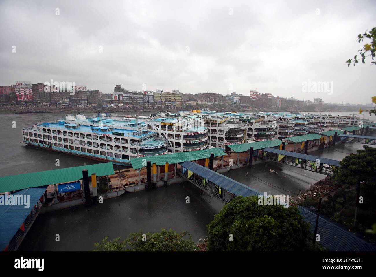 Bangladeshi passengers cross the Buriganga River during the heavy rain ...