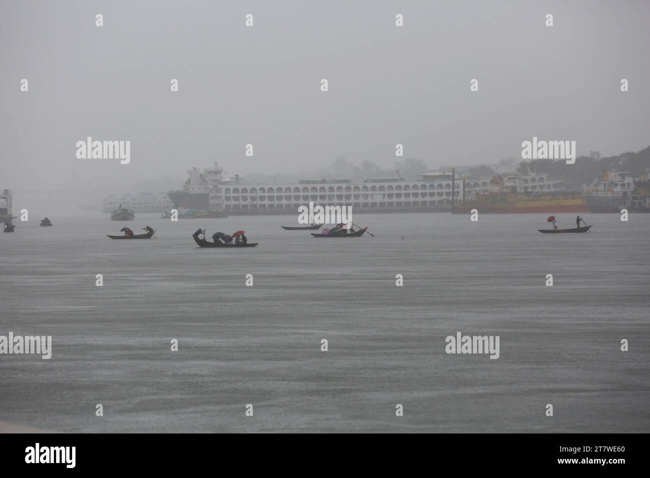 Bangladeshi passengers cross the Buriganga River during the heavy rain ...