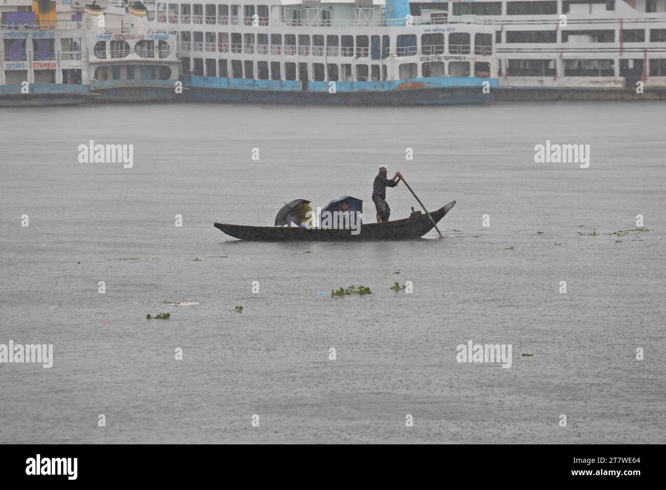 Bangladeshi passengers cross the Buriganga River during the heavy rain ...