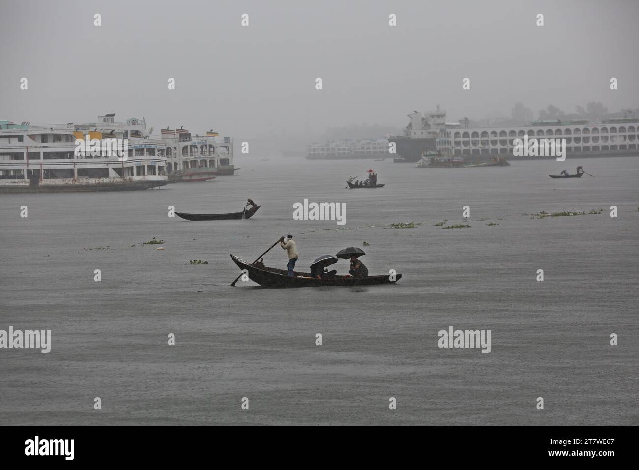 Bangladeshi passengers cross the Buriganga River during the heavy rain ...
