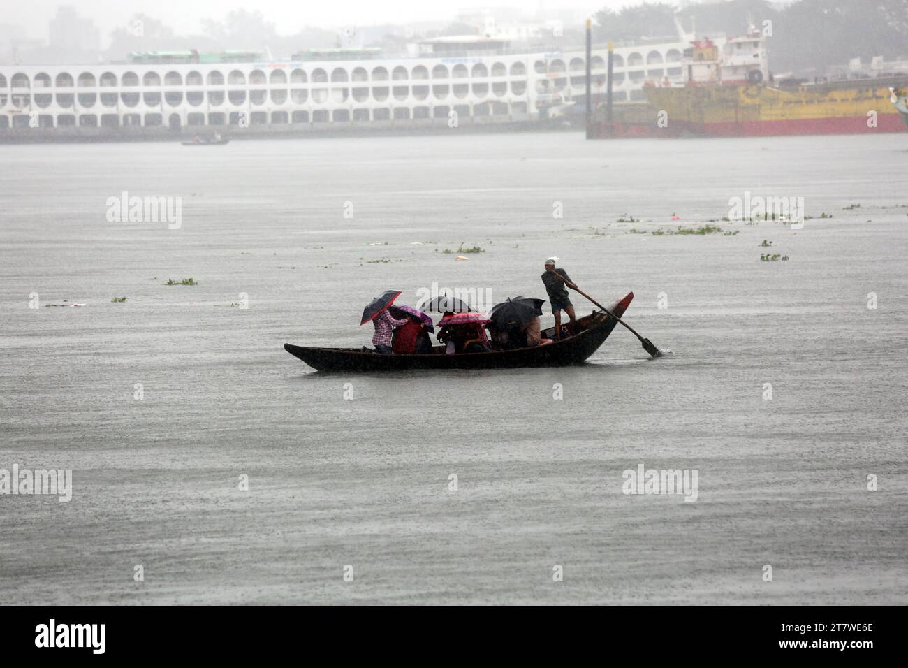 Bangladeshi passengers cross the Buriganga River during the heavy rain ...