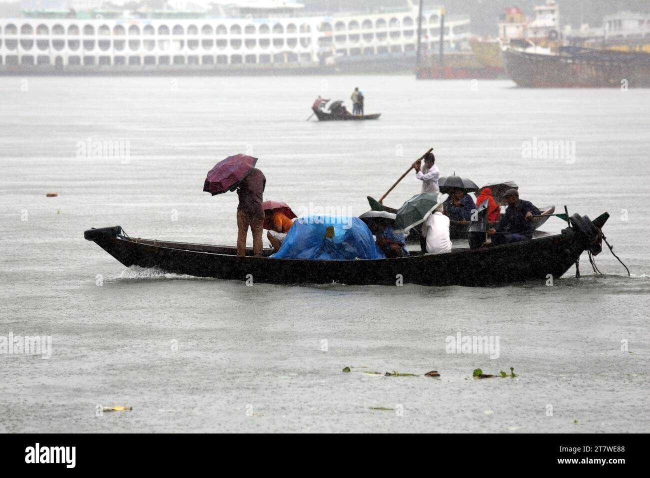 Bangladeshi passengers cross the Buriganga River during the heavy rain ...