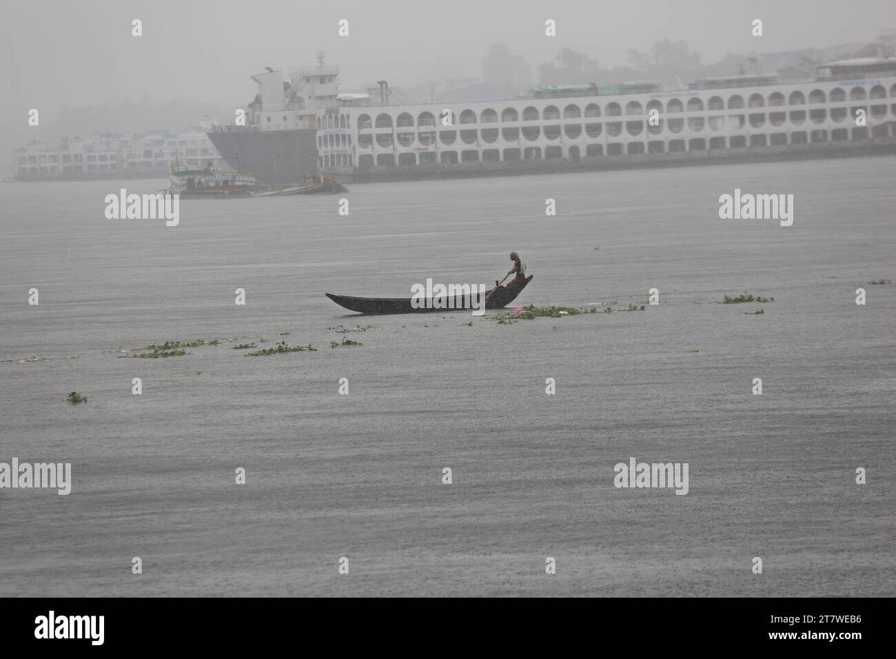 Bangladeshi passengers cross the Buriganga River during the heavy rain ...