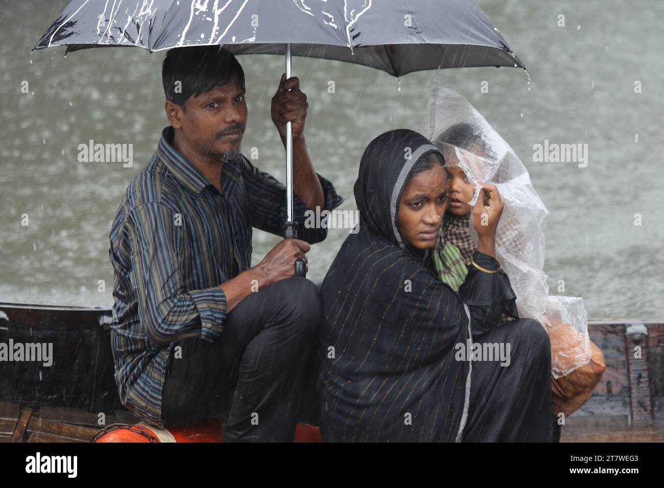 Bangladeshi passengers cross the Buriganga River during the heavy rain ...
