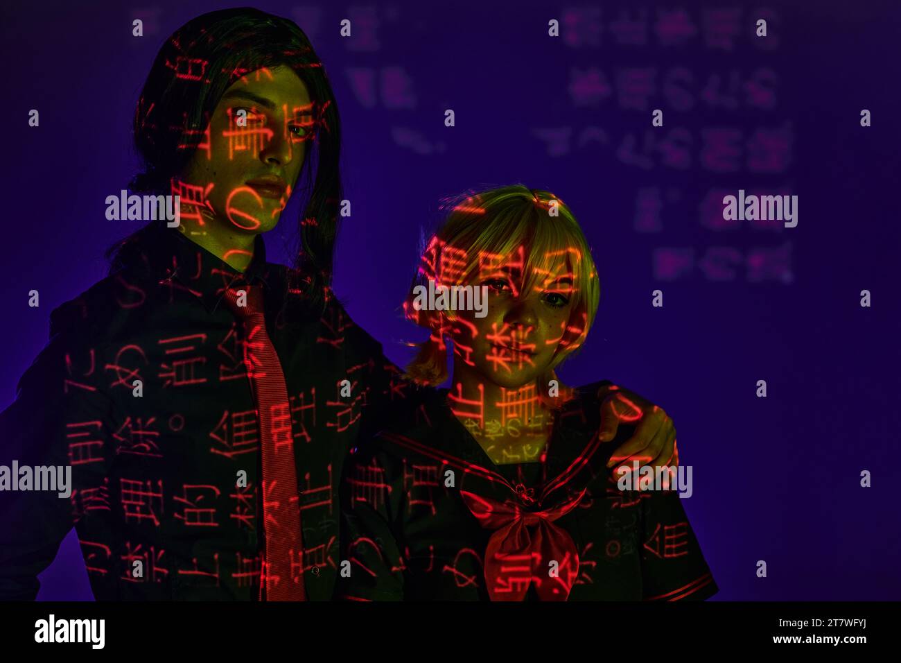 cosplay students in colorful neon projection of hieroglyphs on blue ...