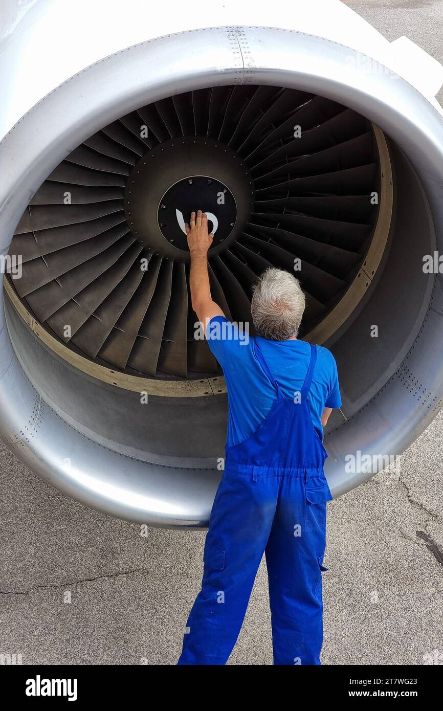technician inspecting airplane engine on airport track Stock Photo - Alamy