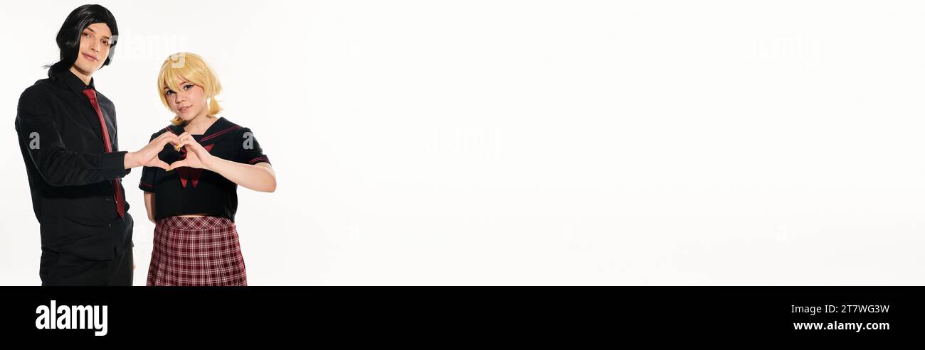 cosplay students in dark uniform and wigs showing heart sign with hands ...