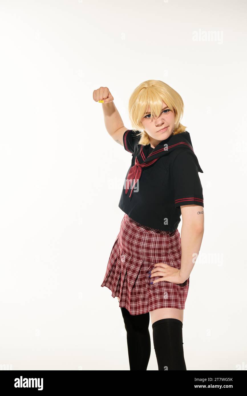 angry woman in school uniform and yellow blonde wig showing fist on ...