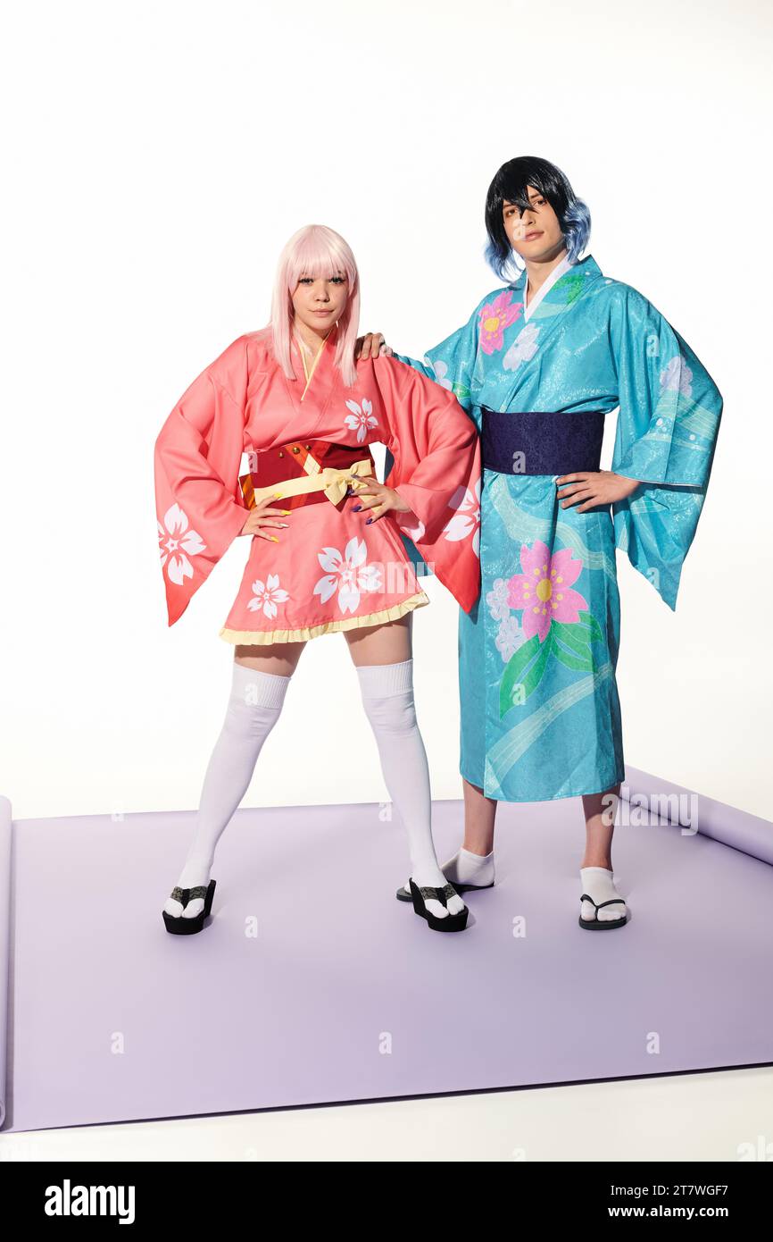 confident expressive couple in colorful kimonos and wings posing with ...
