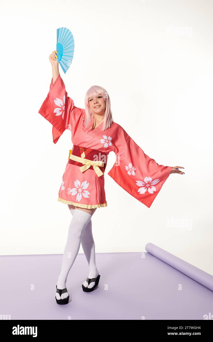 charming anime style woman in pink kimono and wig standing with hand ...
