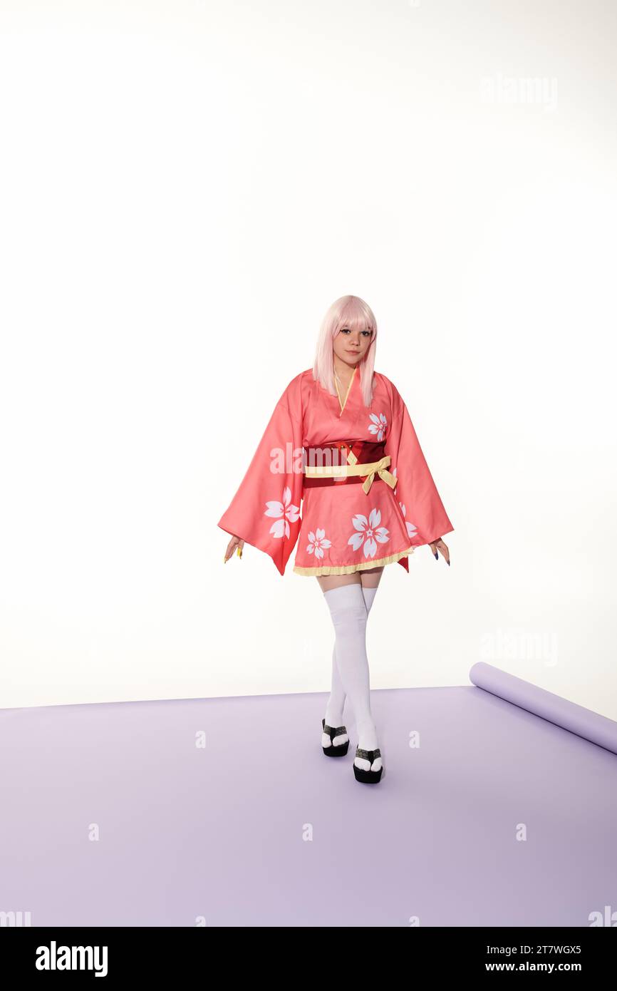 young anime style woman in pink kimono and blonde wig on purple carpet ...