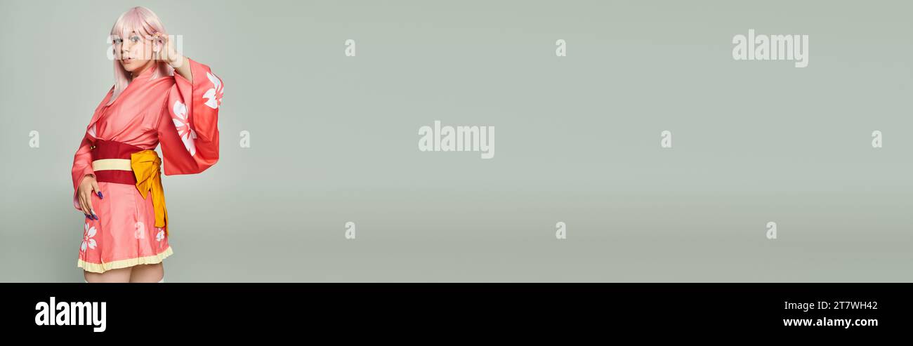 anime style woman in colorful kimono adjusting blonde wig on grey ...