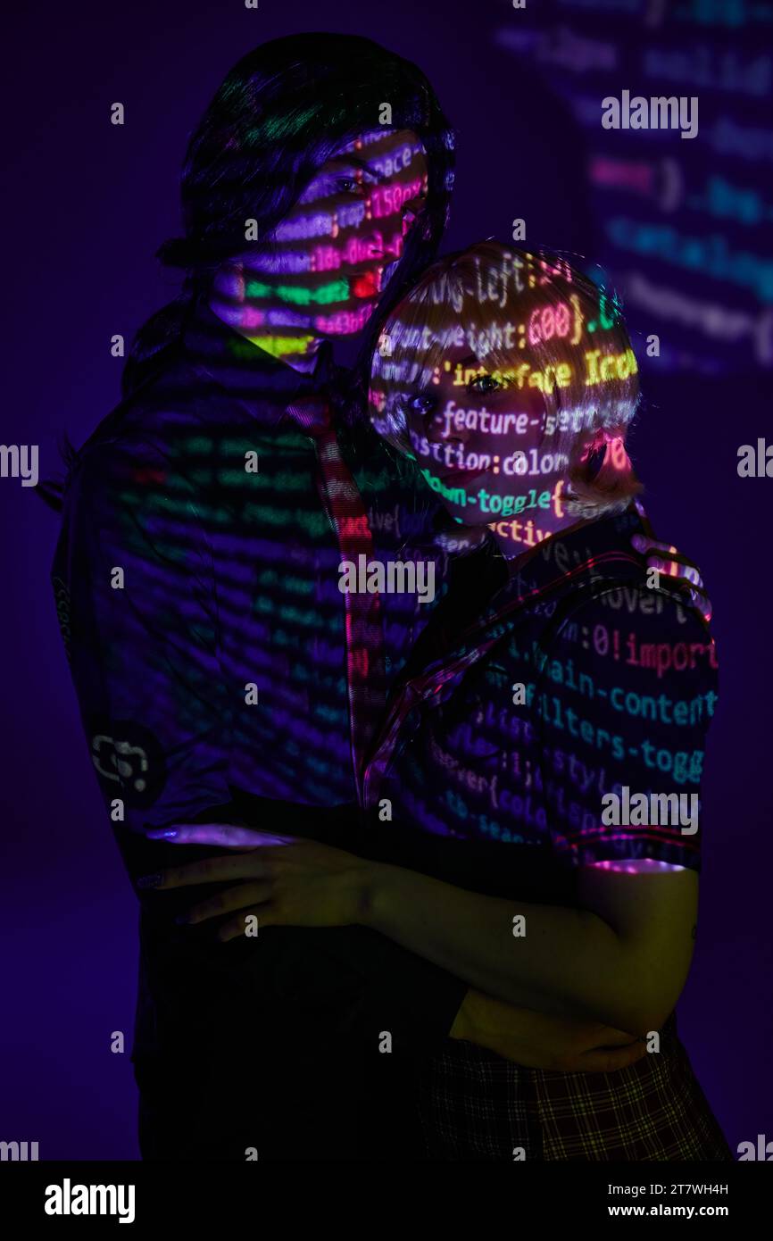 modern couple in colorful neon programming symbols projection on blue ...