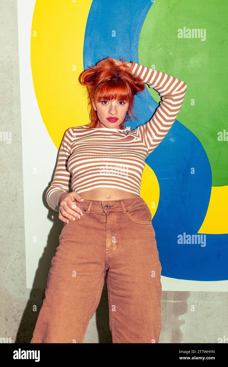 Young redhead Caucasian woman in retro style of 70s posing at colorful ...