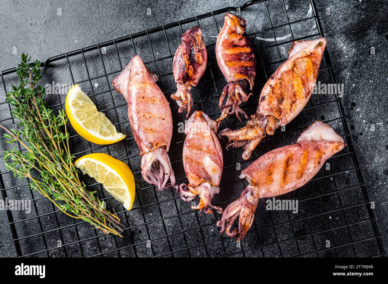 Bbq squid calamary on a rack. Black background. Top view Stock Photo ...
