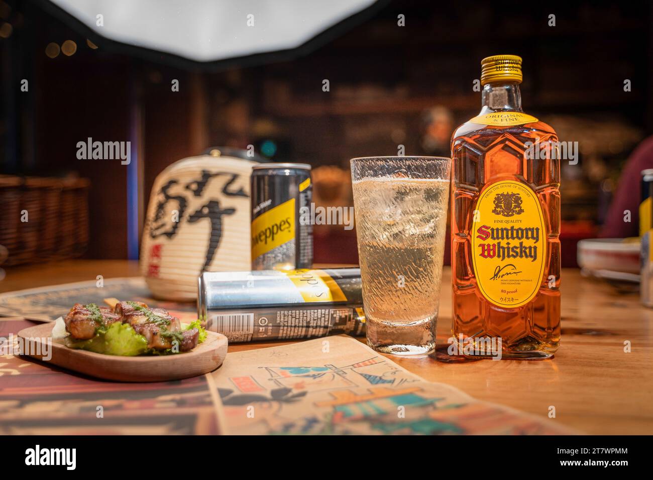 A rustic wooden table displays an array of alcoholic beverages ...
