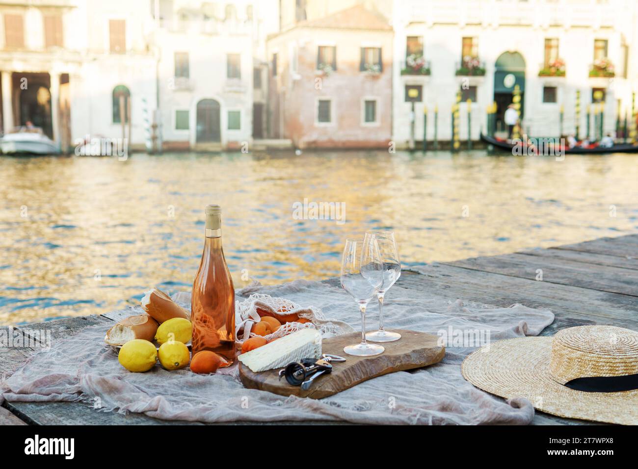 Rose wine, fruits and snacks on the wooden pier during picturesque ...