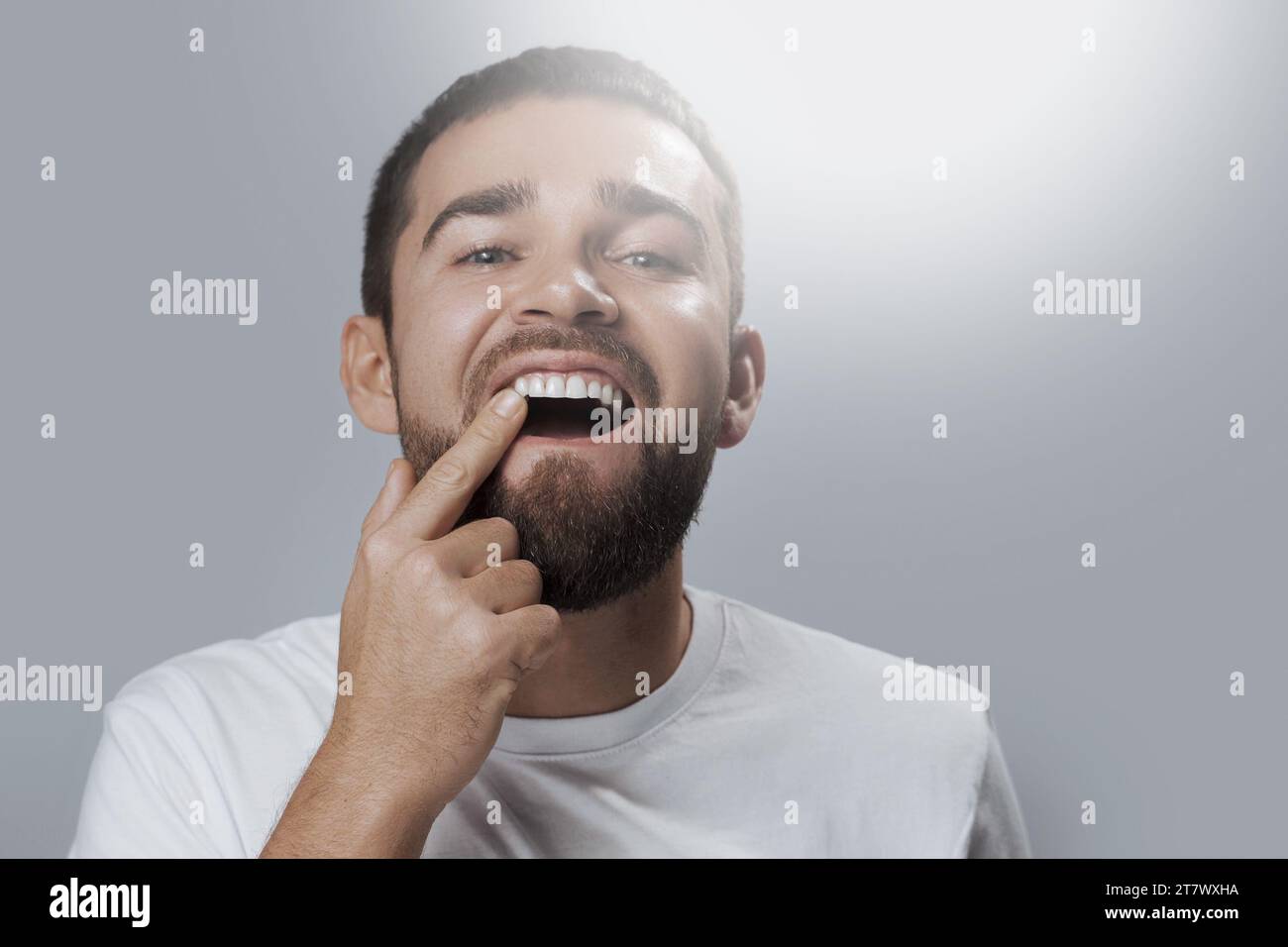 Bearded man checking his teeth health condition Stock Photo - Alamy