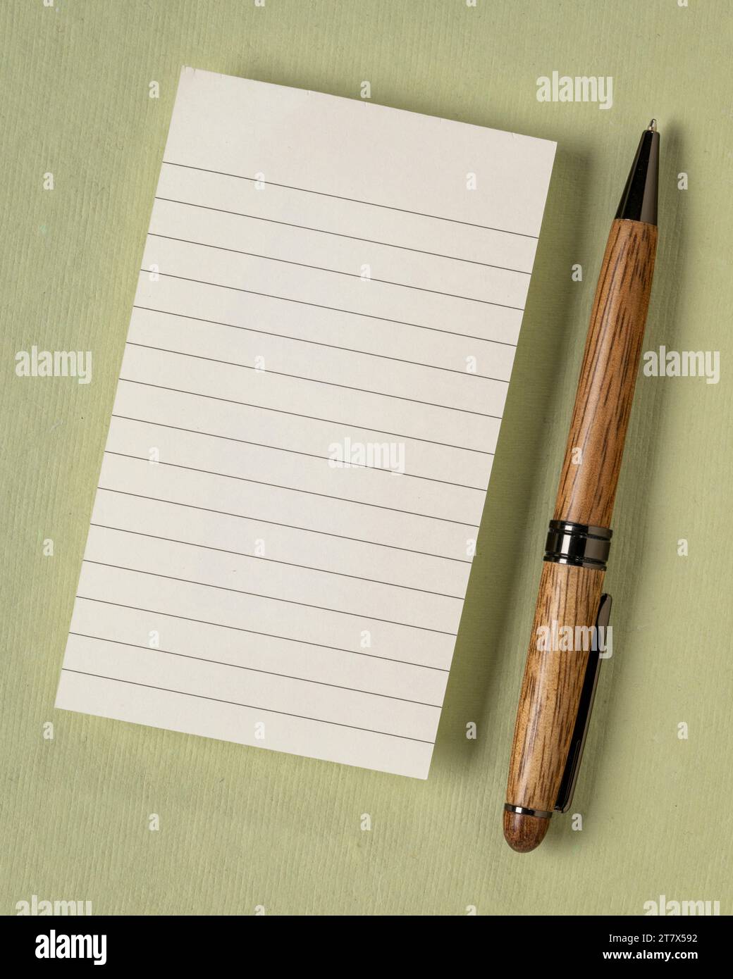 blank sheet of ruled paper in a small journal with a luxury pen against ...