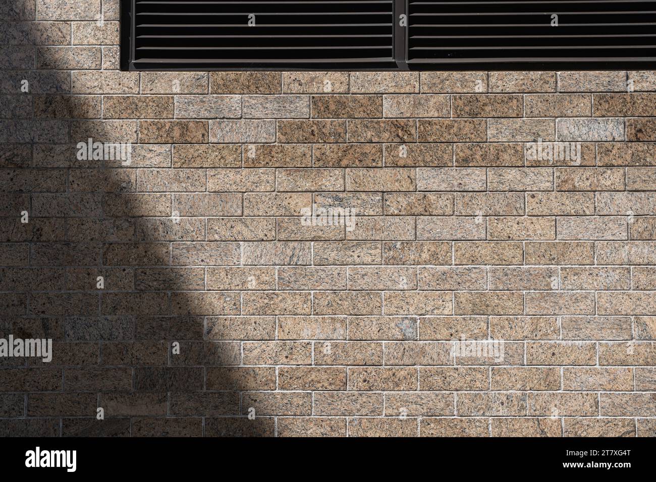 Brick wall with ventilation grilles providing a unique backdrop for ...