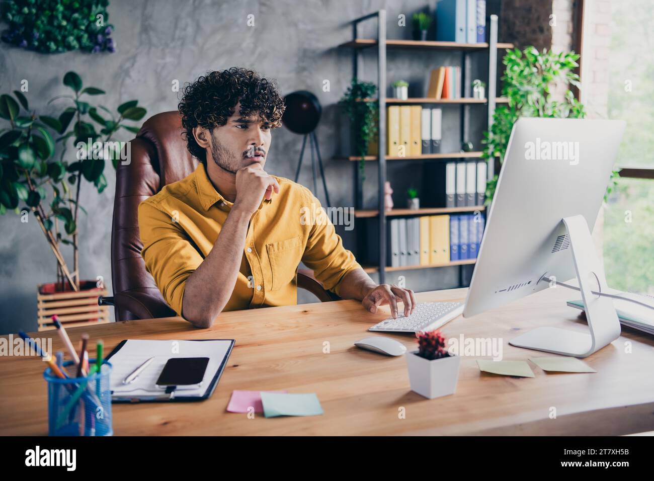 Photo of successful minded man sitting work table browsing database ...