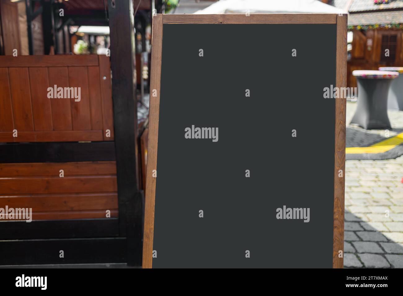 Wooden rustic blackboard in front of restaurant entrance. Mock up menu ...