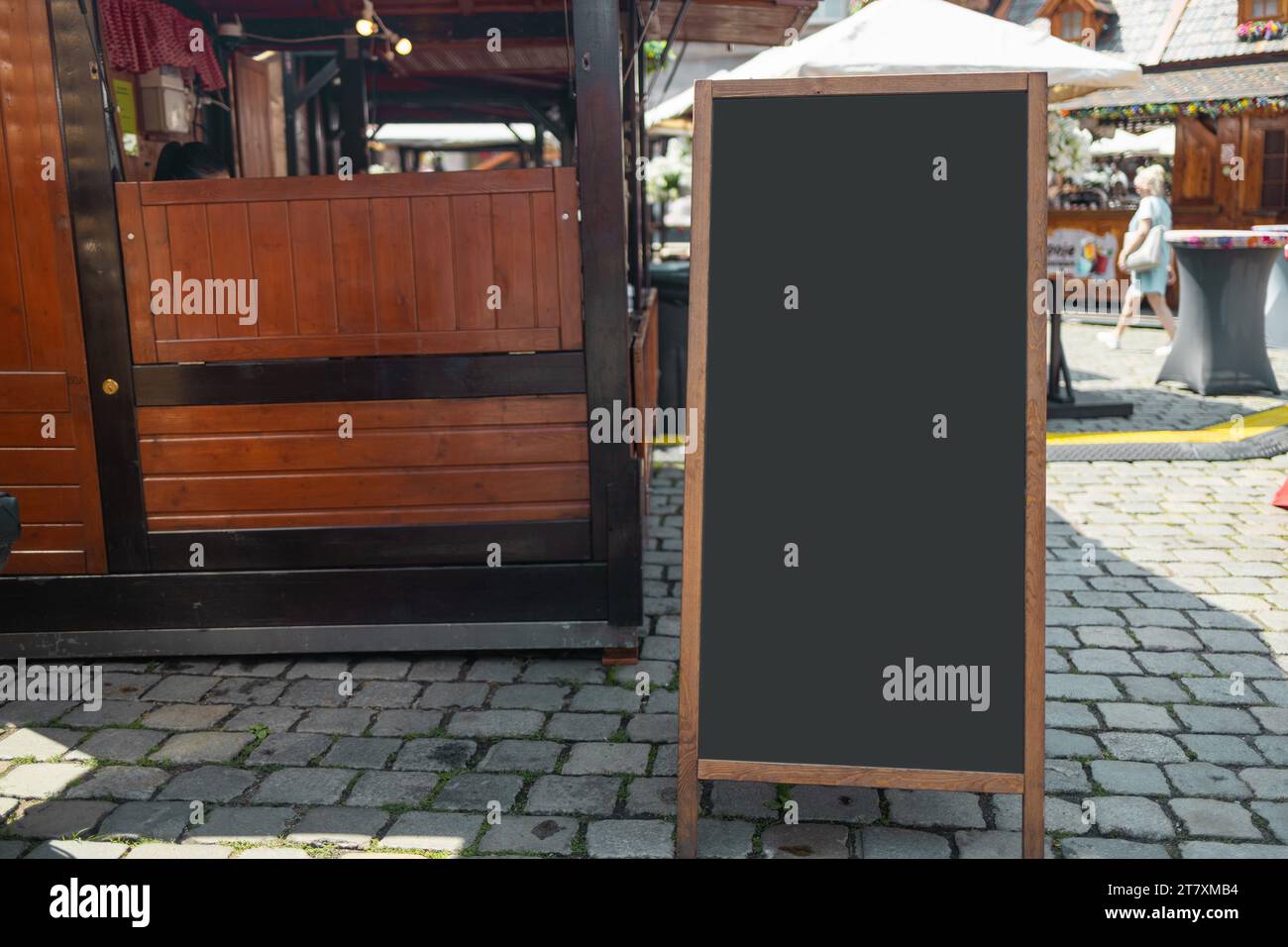 Wooden rustic blackboard in front of restaurant entrance. Mock up menu ...