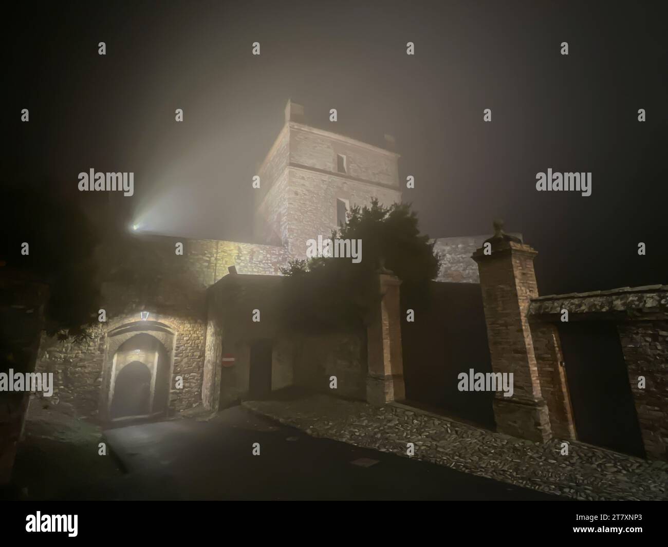 The tower and gate of a medieval castle in a small town during a winter ...