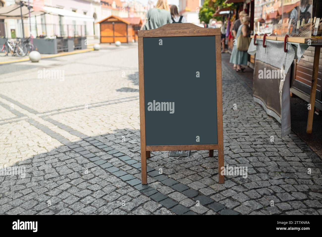 Wooden rustic blackboard in front of restaurant entrance. Mock up menu ...