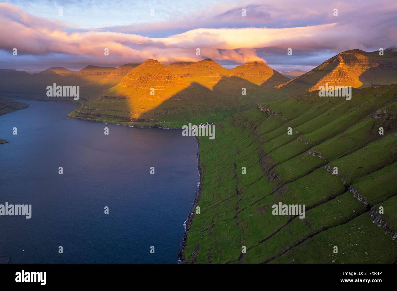 Aerial shot of the dramatic view of Funningur with pink sky at dawn ...