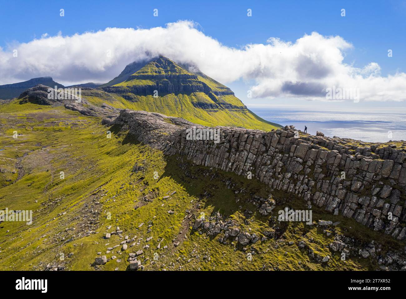 One person hikes the ridge toward the Skaelingsfjall mountain, Streymoy ...
