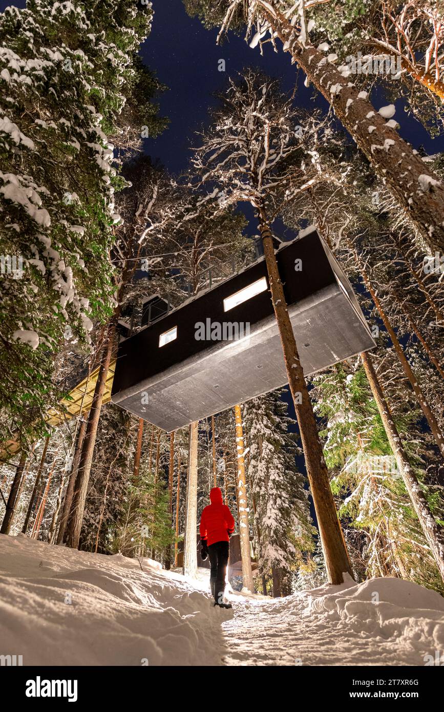 Tourist admires the elevated hotel room capsule shaped among snowy ...
