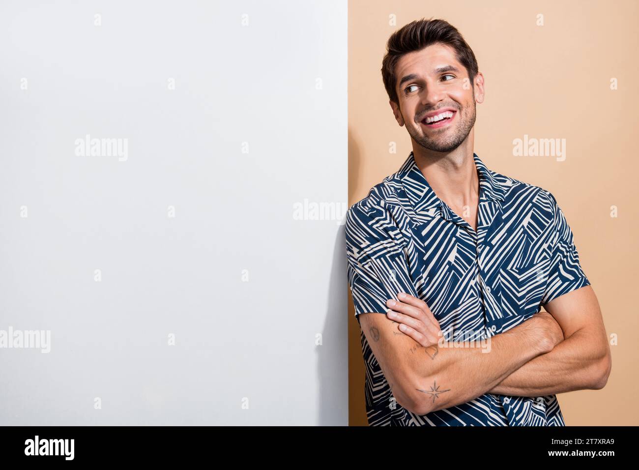 Photo of young cheerful guy folded hands looking empty space placard ...